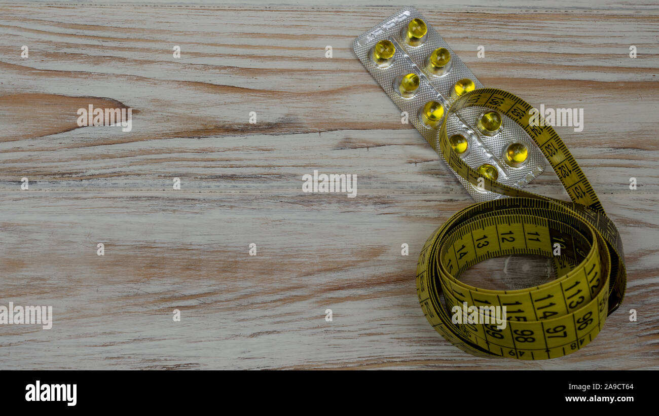measuring tape yellow round tablets on light background Stock Photo - Alamy