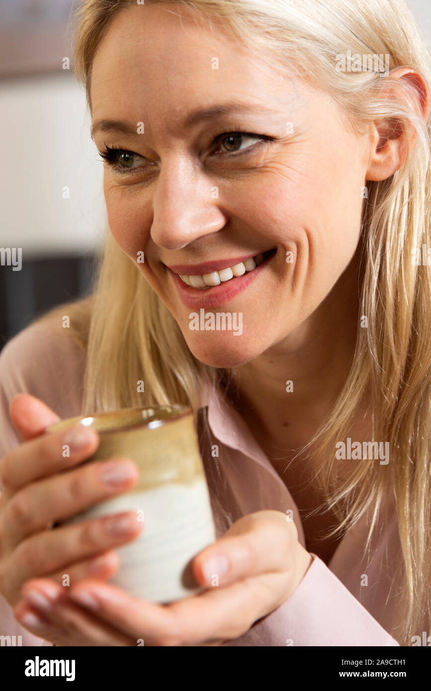 Woman, smiling, holding teacup, portrait, detail Stock Photo - Alamy
