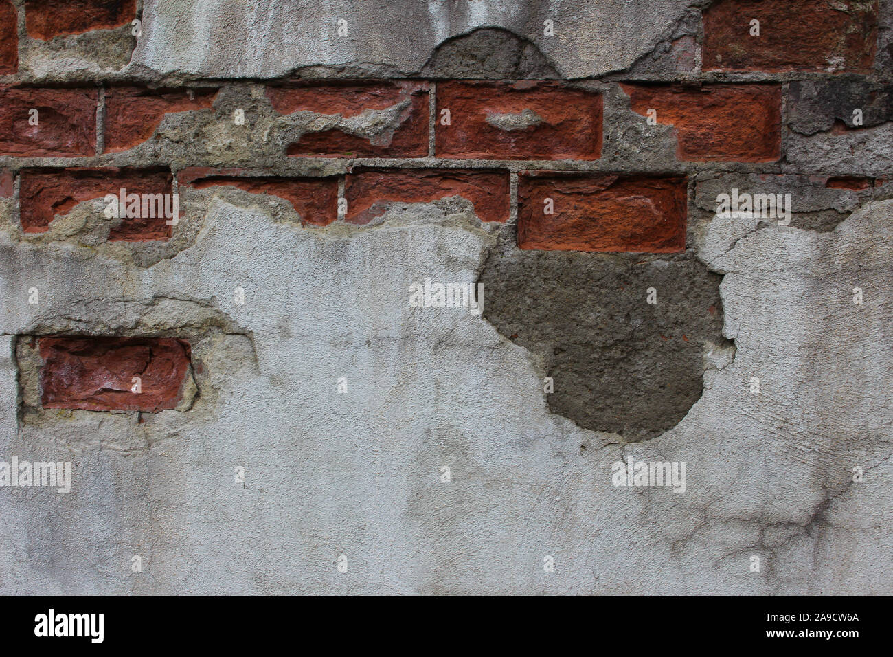 Plaster fallen off a brick wall revealing damaged bricks under it Stock ...