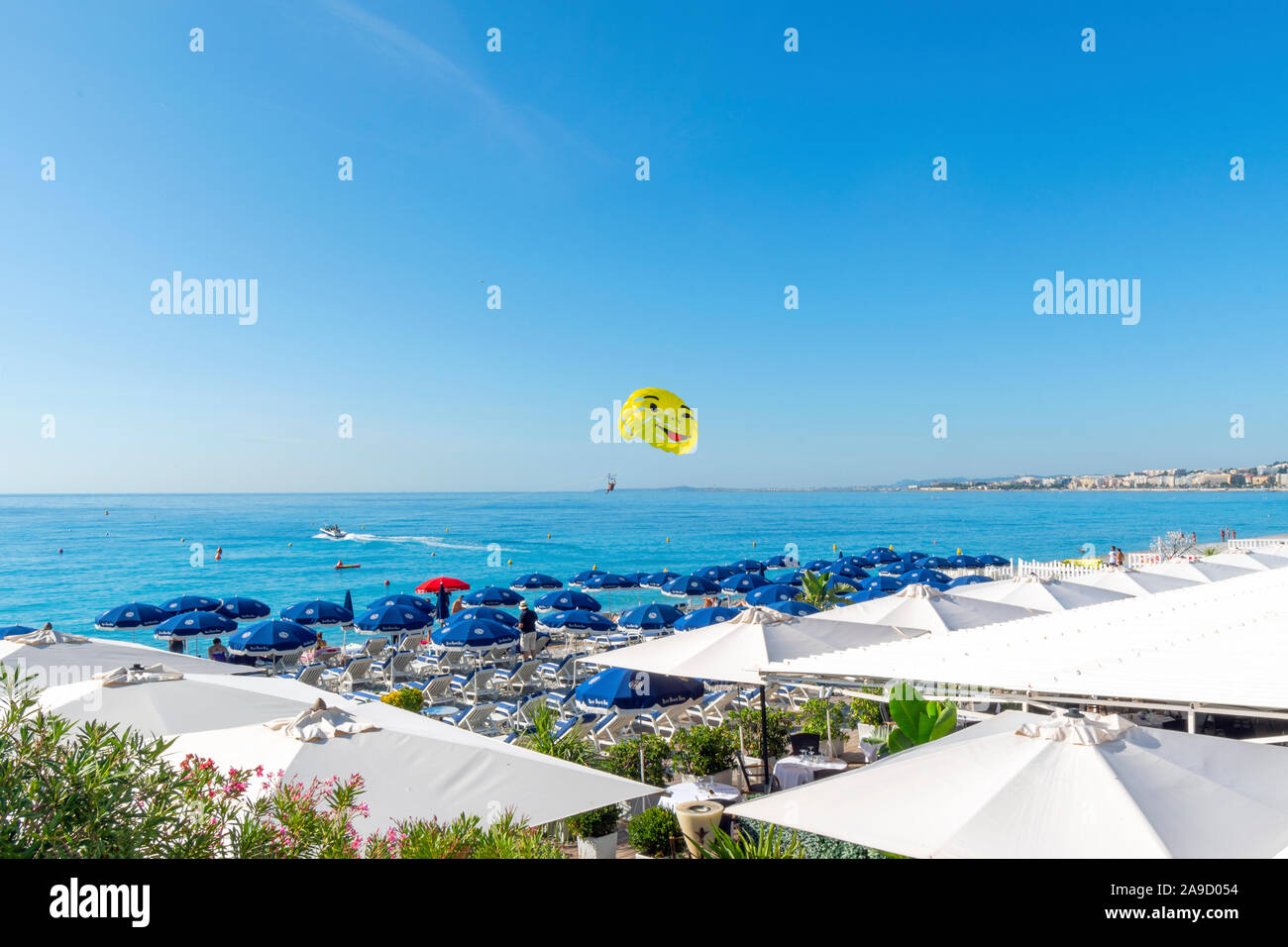 A happy smiley face parachute parasailer takes off from a beach resort ...