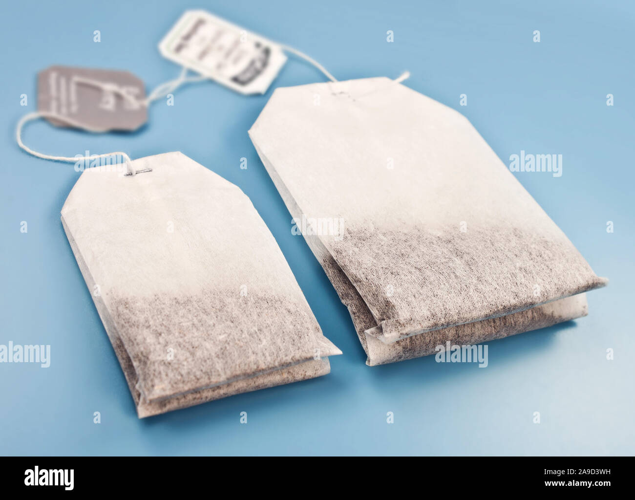 Two tea bags and blue background Stock Photo - Alamy