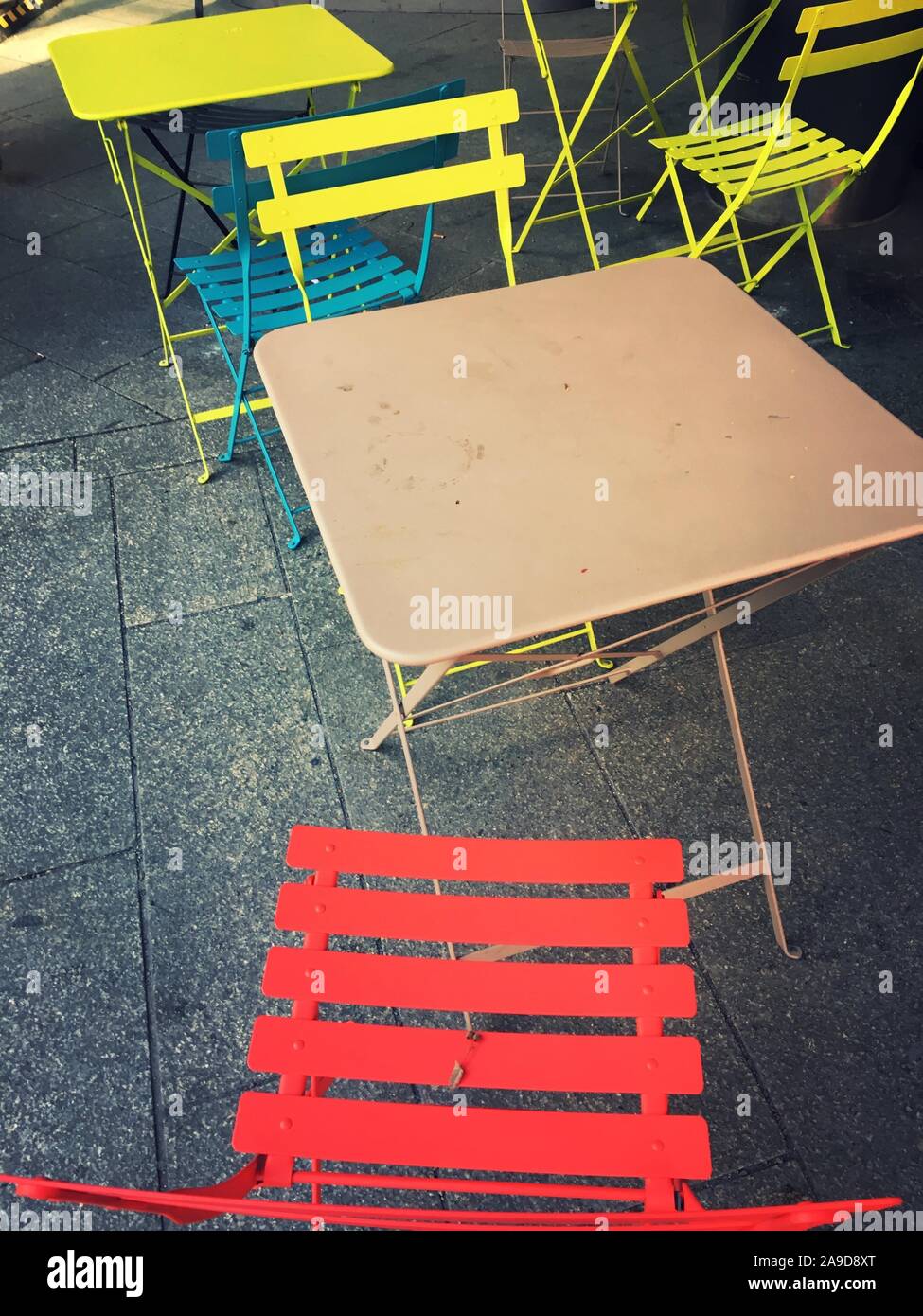 Tables and colorful chairs, sitting outside Stock Photo - Alamy