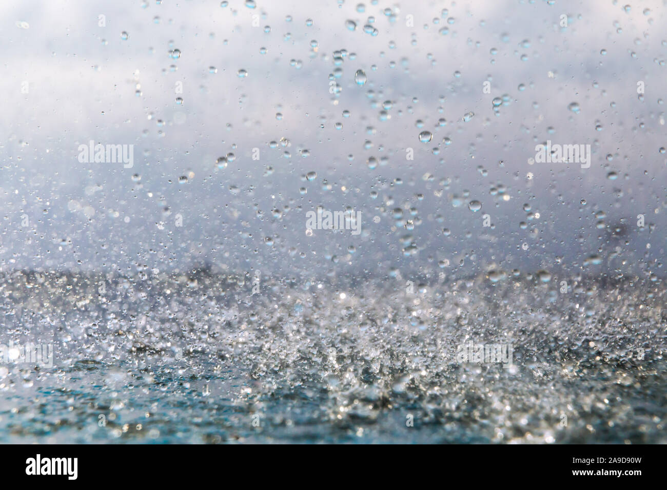 Close-up of falling raindrops in front of dark gray sky Stock Photo - Alamy