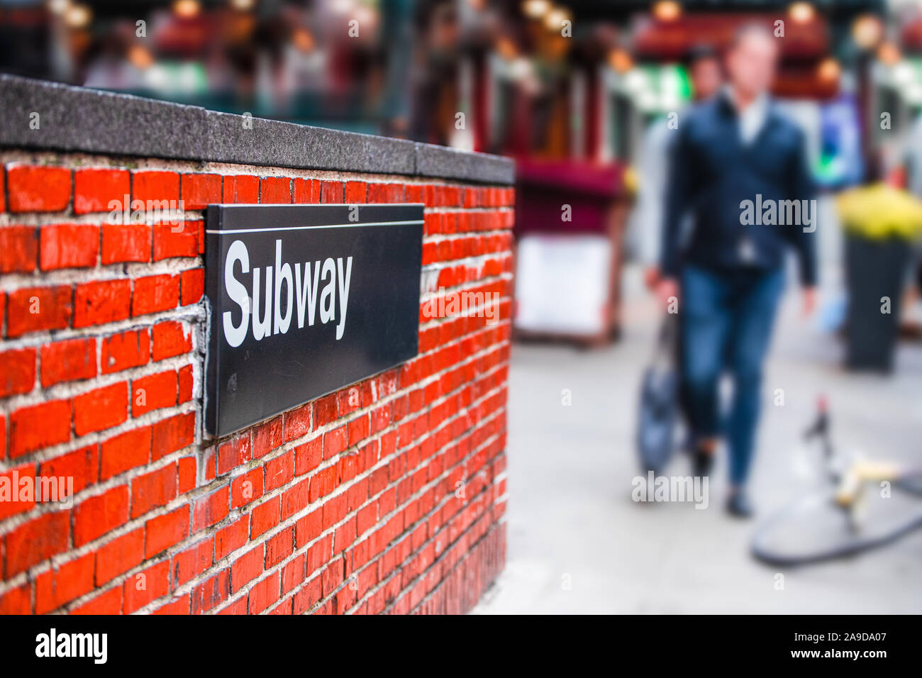 New York City street corner subway entrance with sign on brick wall and ...
