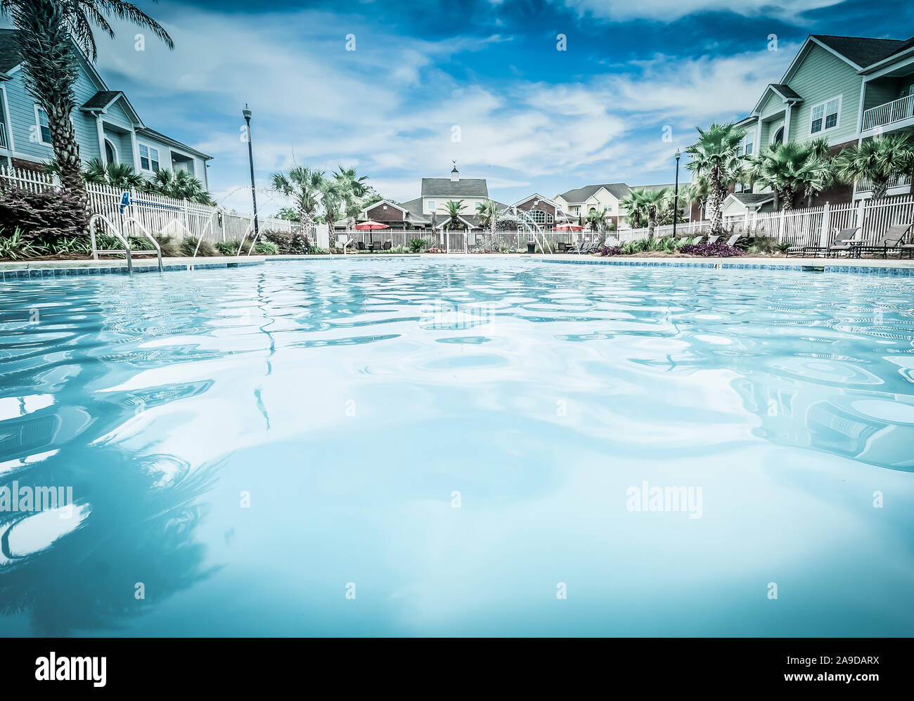 A large, curvy built-in zero entry swimming pool is a focal point for ...