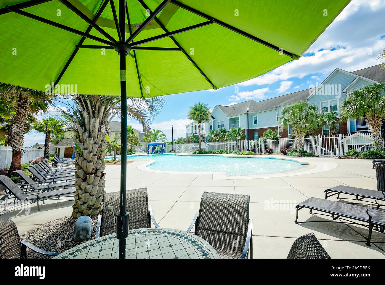 A patio umbrella shades a table by the built-in swimming pool at ...