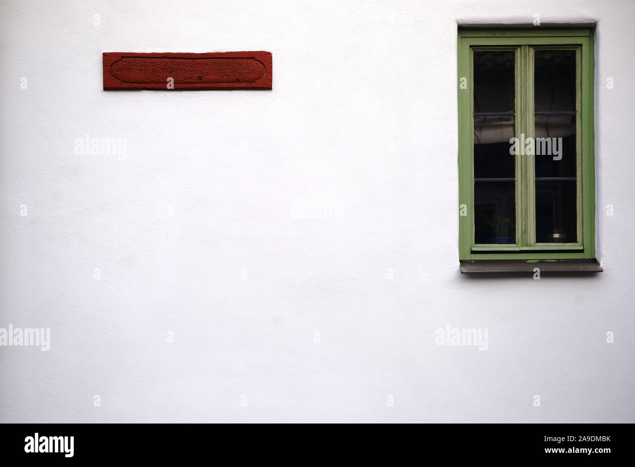 A nostalgic window with a green frame and a wooden sign Stock Photo - Alamy