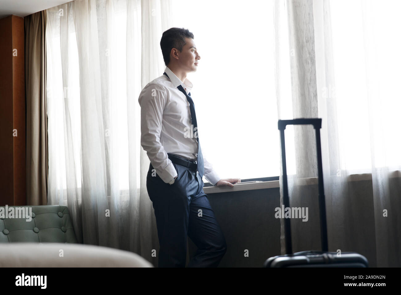 The young man standing in a hotel room Stock Photo - Alamy