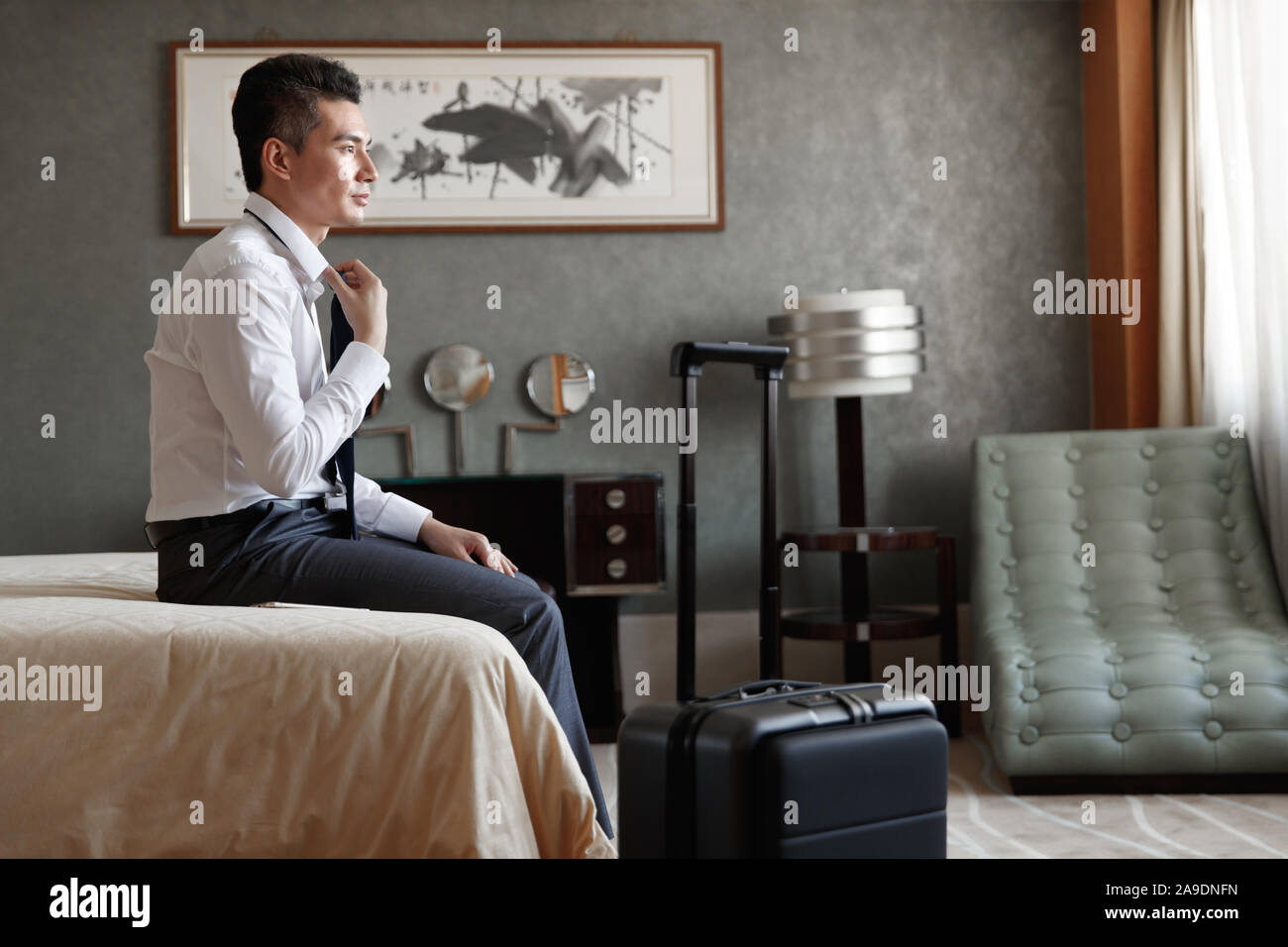 The young man sitting in a hotel room Stock Photo - Alamy