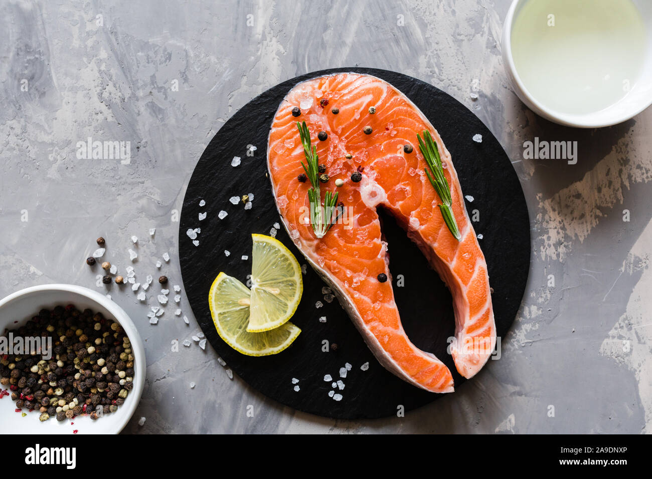 Fresh raw salmon fish steak with spices on dark stone background ...