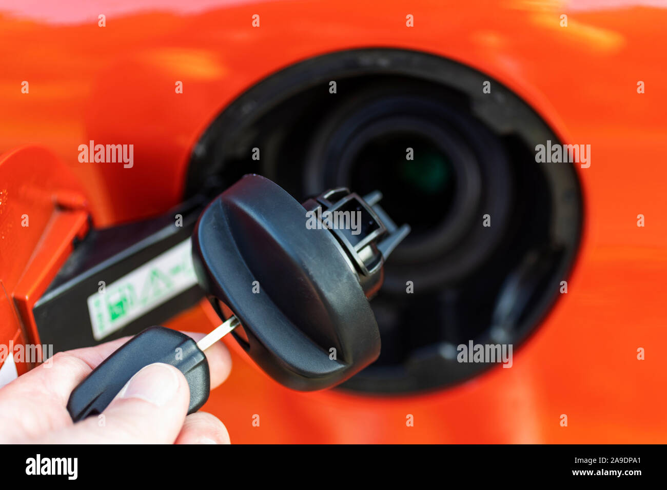 Man's hand holding fuel tank cap in front of gasoline filler neck Stock ...