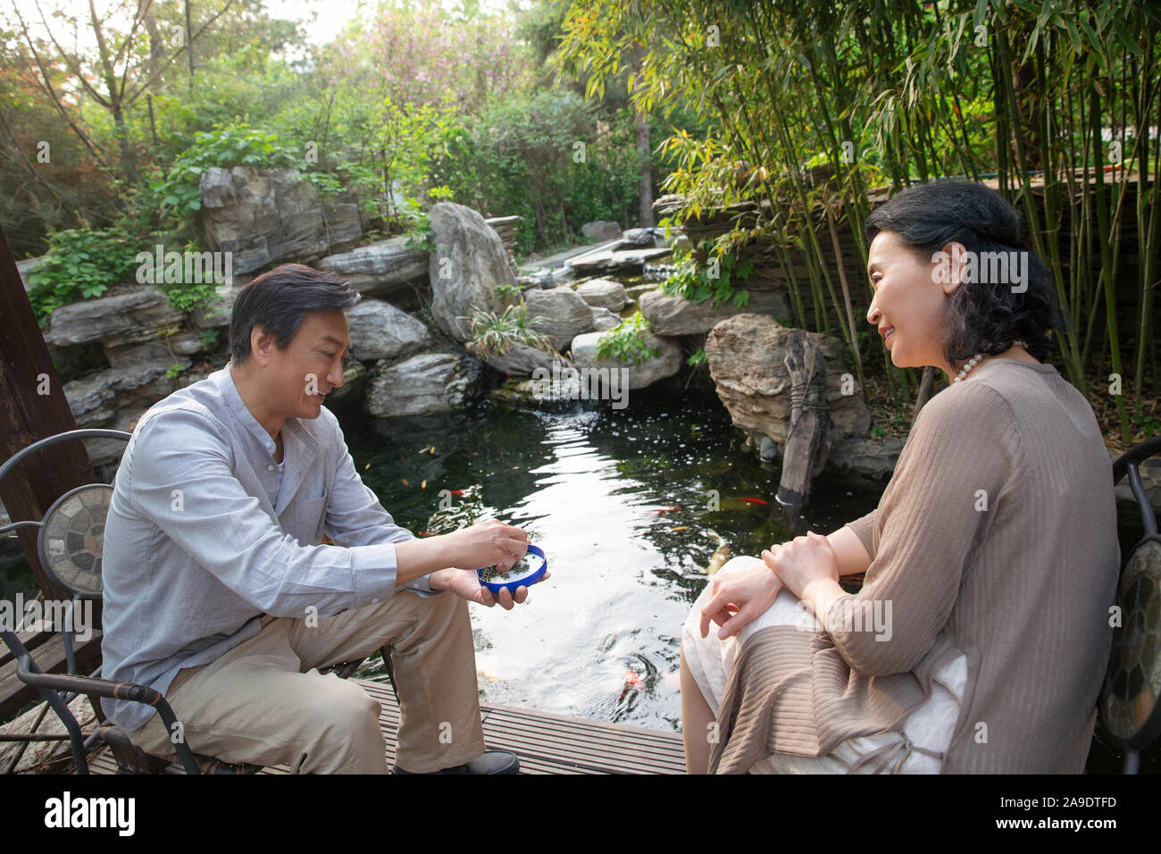 Two women feeding fish hi-res stock photography and images - Alamy