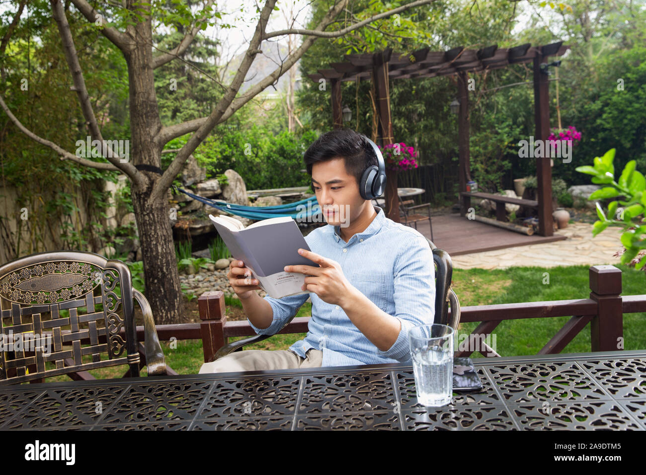Young man reading in a courtyard hi-res stock photography and images ...