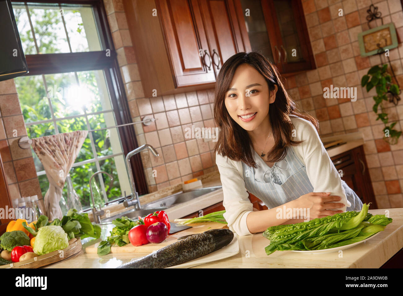 Young woman is cooking in the kitchen Stock Photo - Alamy