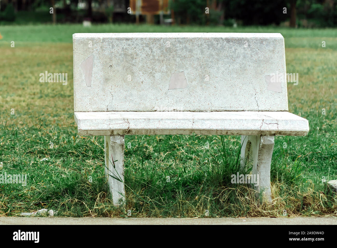 Old and broken long white cement bench for relaxing after the exercise ...