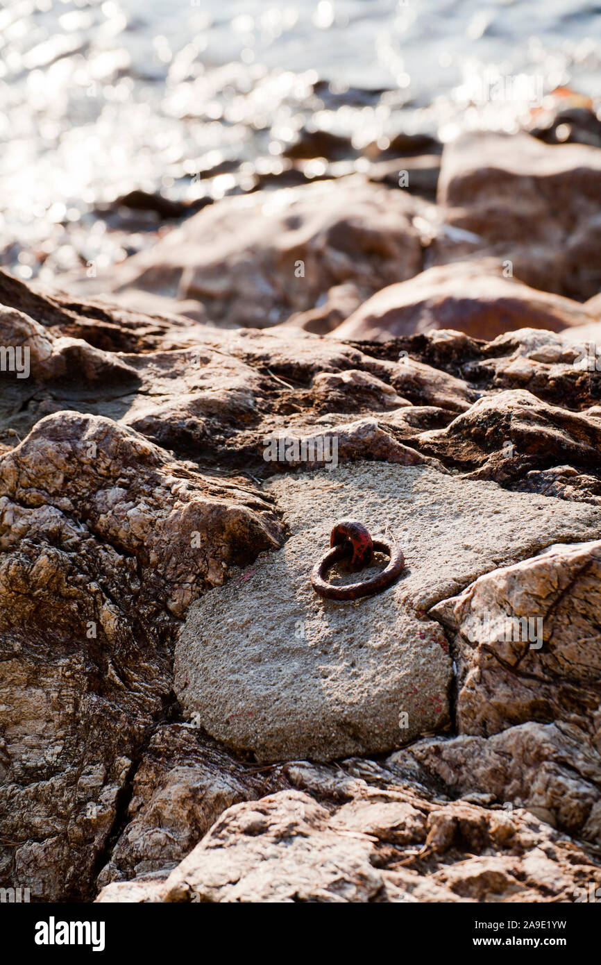 Ring hooks anchored on rocky cliff Stock Photo - Alamy