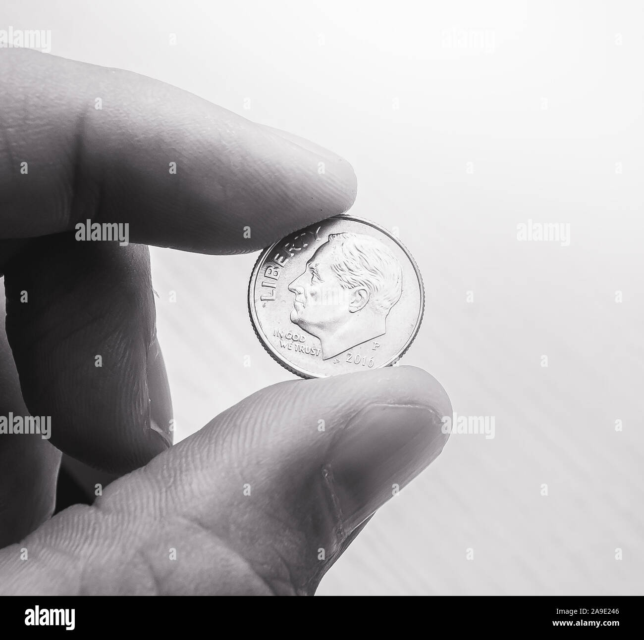 Photograph of a man holding an american dollar dime Stock Photo - Alamy