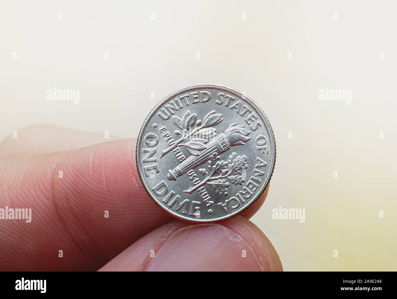 Photograph of a man holding an american dollar dime Stock Photo - Alamy
