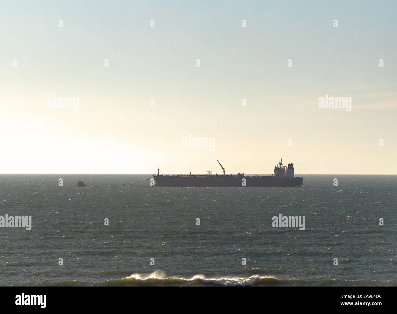 An oil tanker anchored at Tramandai Beach, in the process of ...