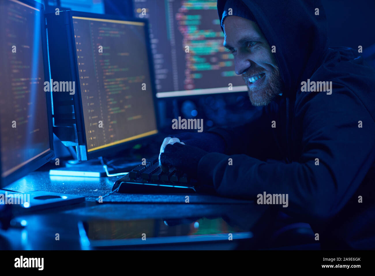 Angry computer hacker in black hood shirt enjoying the process of ...