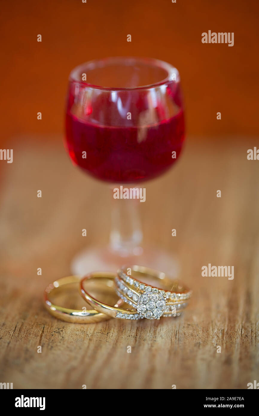 Bridal rings in front of a glass of red wine Stock Photo - Alamy
