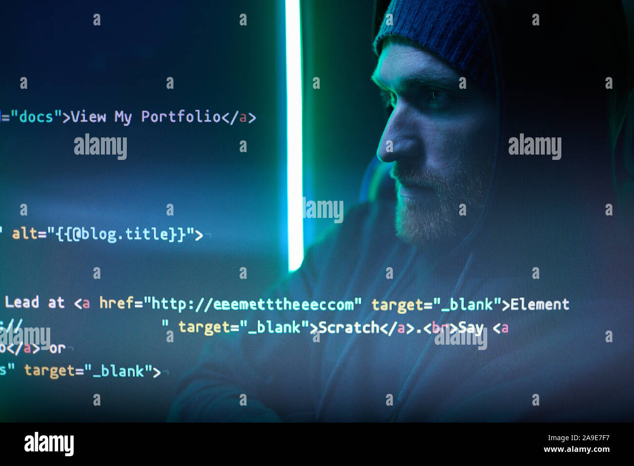 Computer hacker in hoody sitting in front of computer monitor and ...
