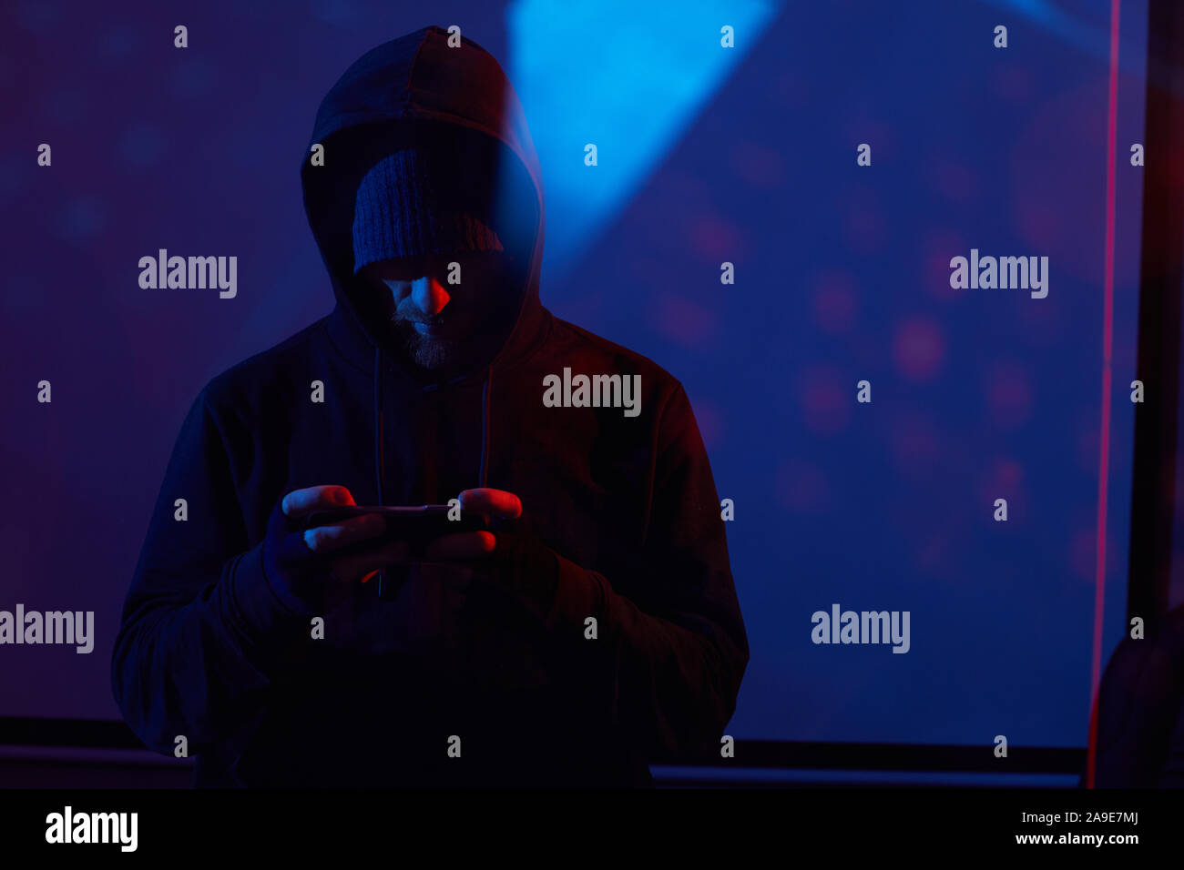Image of computer hacker in black clothing standing and using his ...