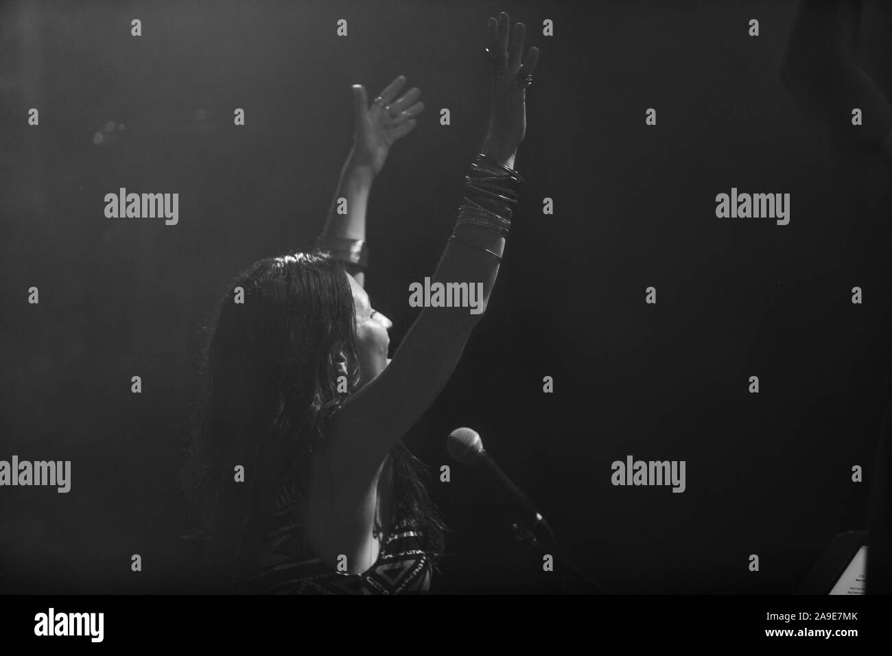 a female musician is viewed from a low angle as she sings and performs ...