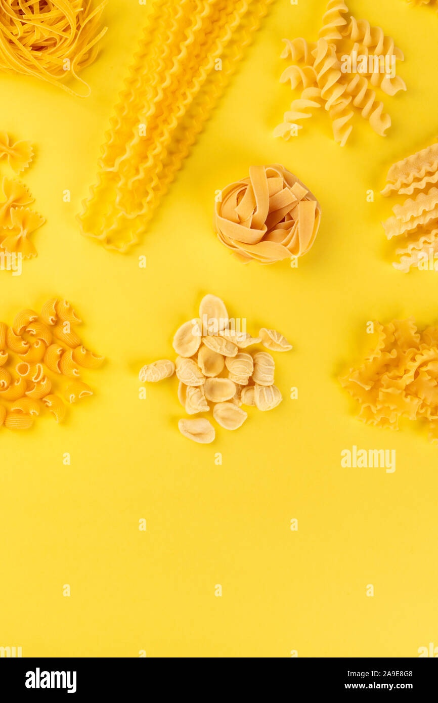 Italian pasta, top-down shot on a yellow background with a place for ...