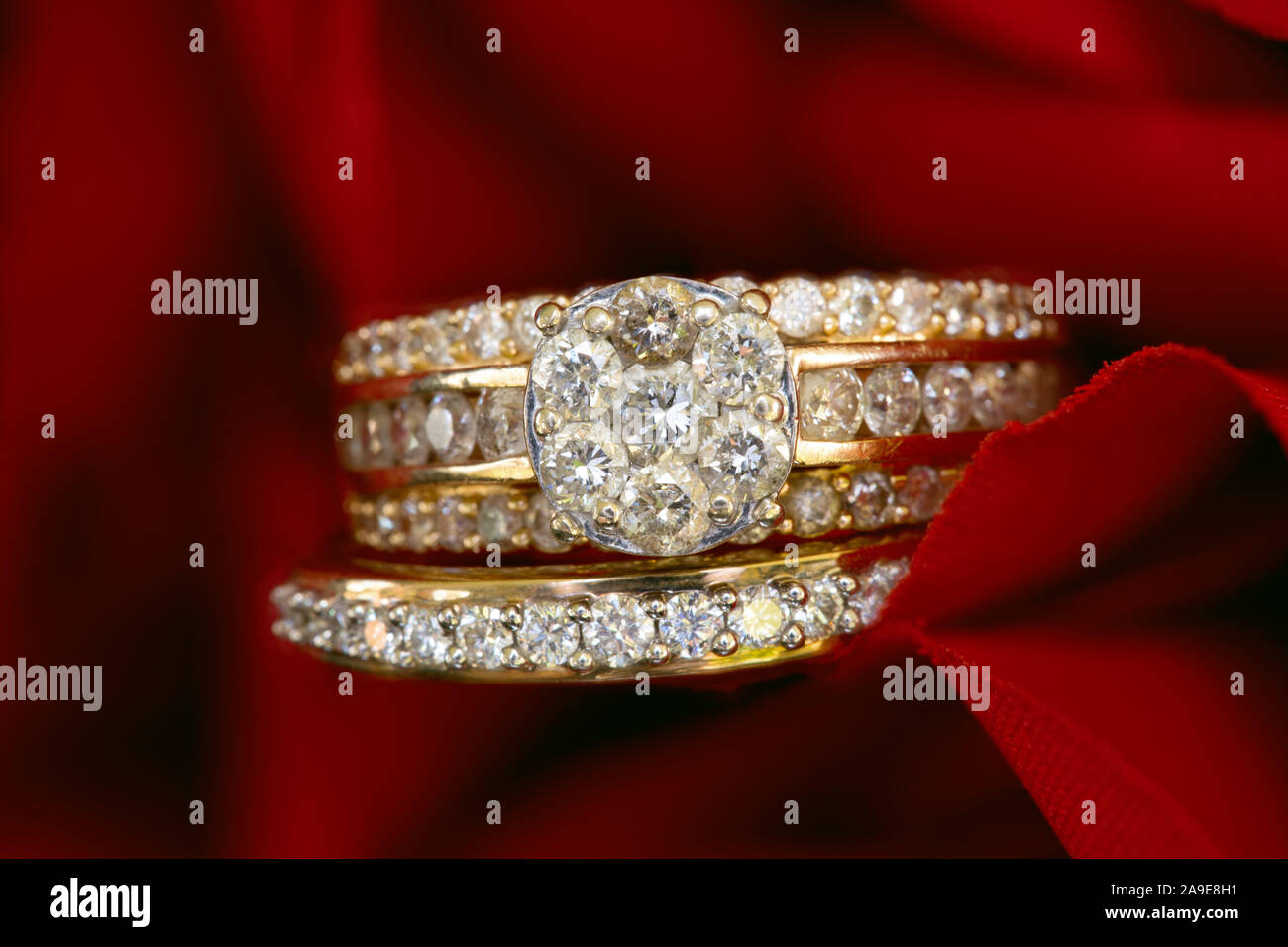 Diamond wedding and engagement rings on a red background Stock Photo ...