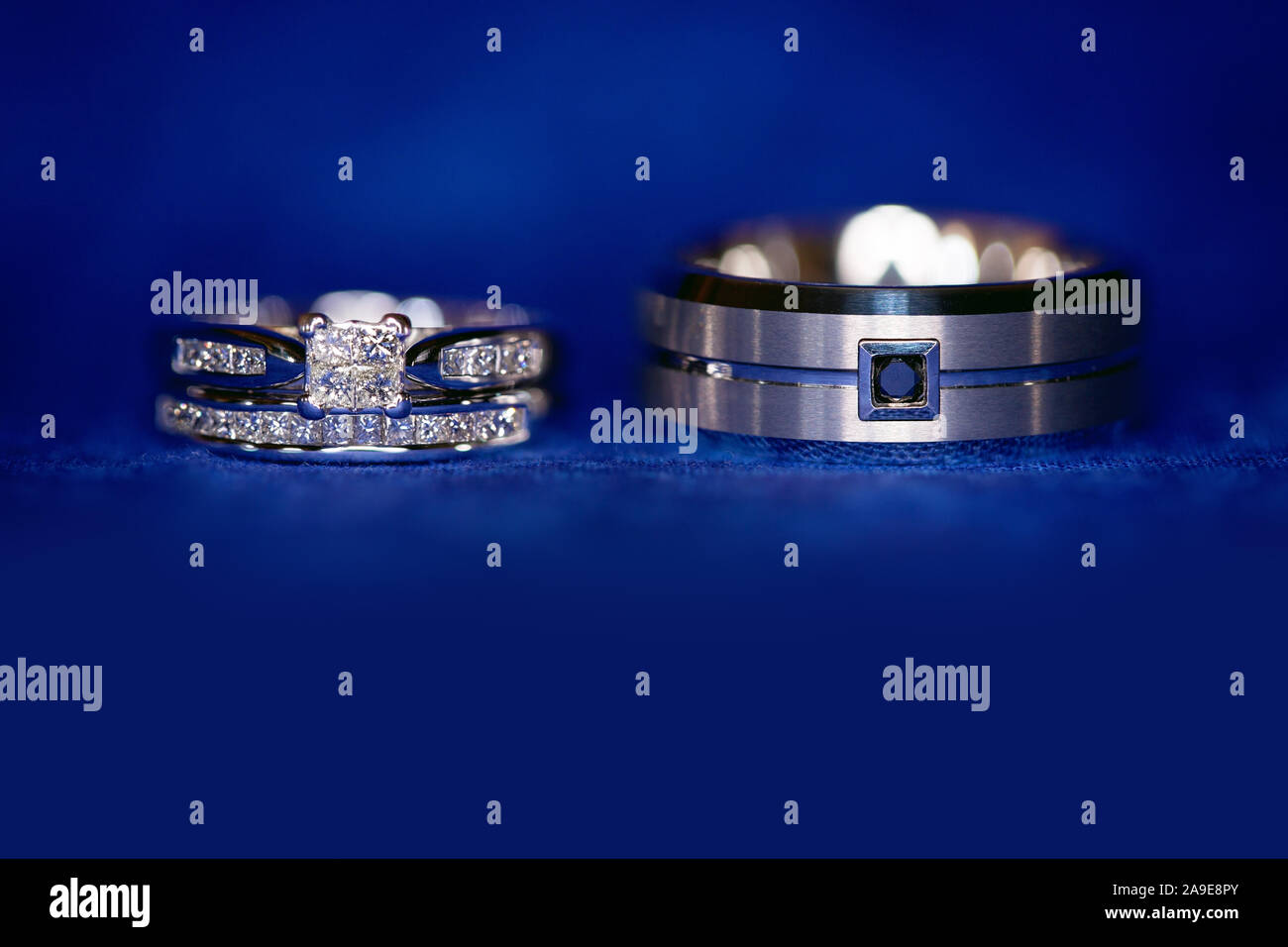 Wedding rings side by side on a blue background Stock Photo - Alamy