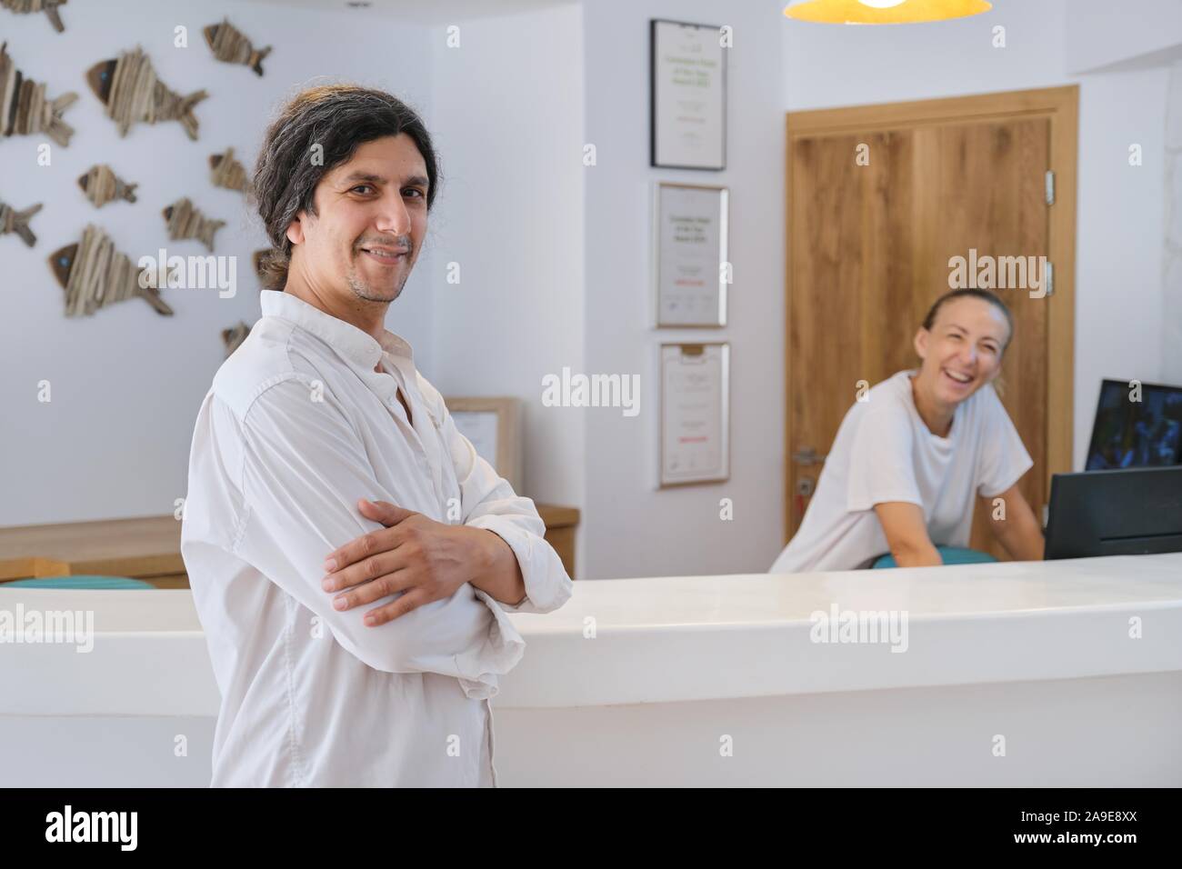 Receptionist standing at the hotel reception counter and smiling hi-res ...