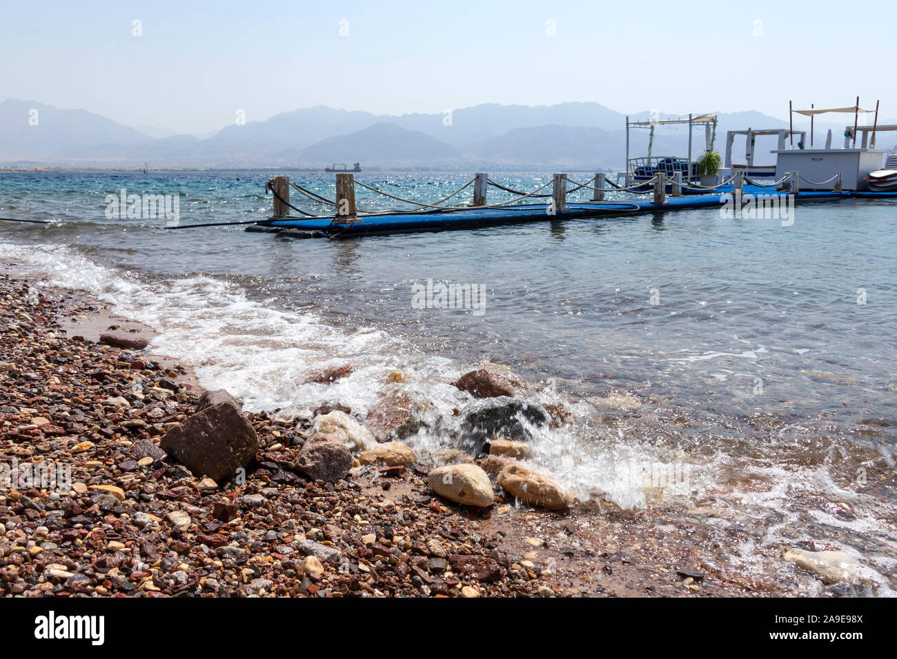 Rocky beach with a floating pier in the Gulf of Eilat Red Sea. Israel ...