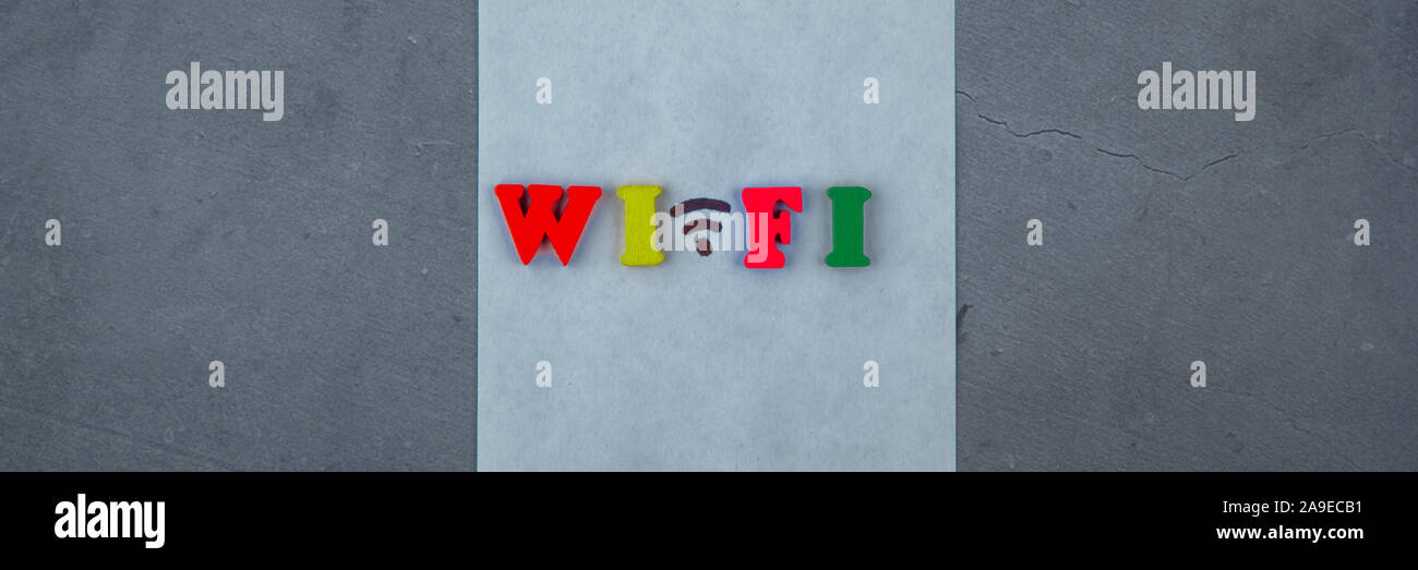 The multicolored wi-fi word is made of wooden letters on a grey ...