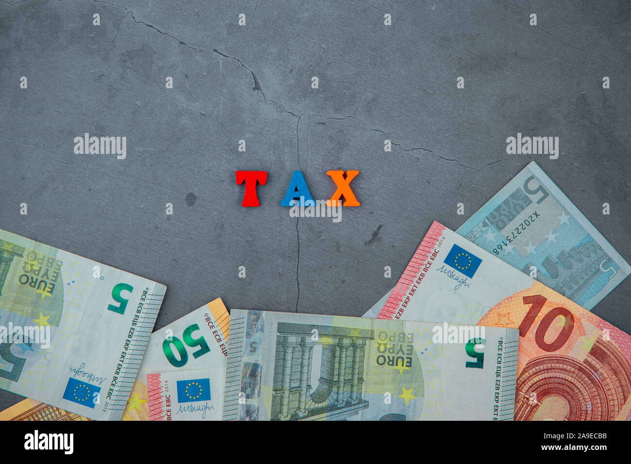 The multicolored tax word is made of wooden letters on a grey plastered ...