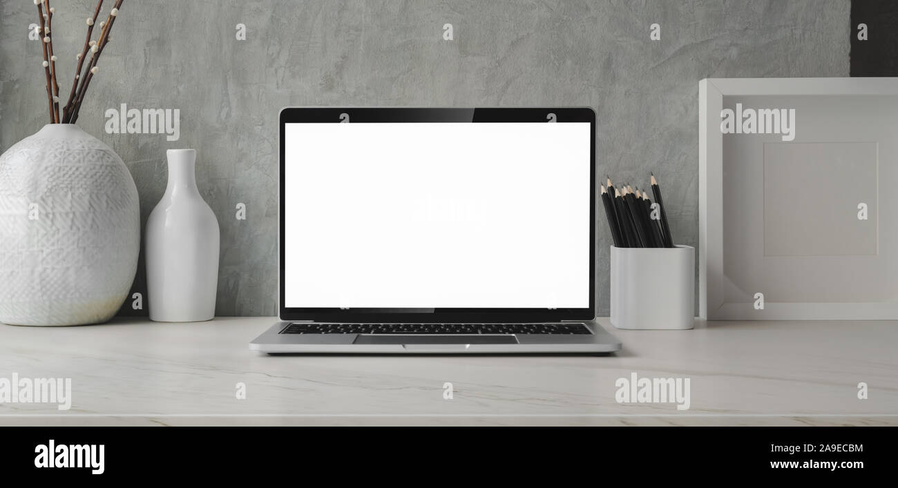 Minimal workspace with blank screen laptop computer and ceramic vase ...