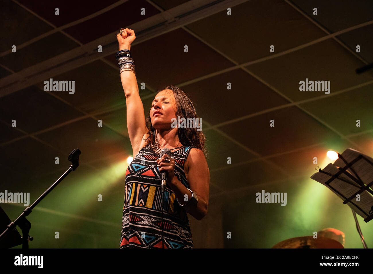 a female musician is viewed from a low angle as she sings and performs ...