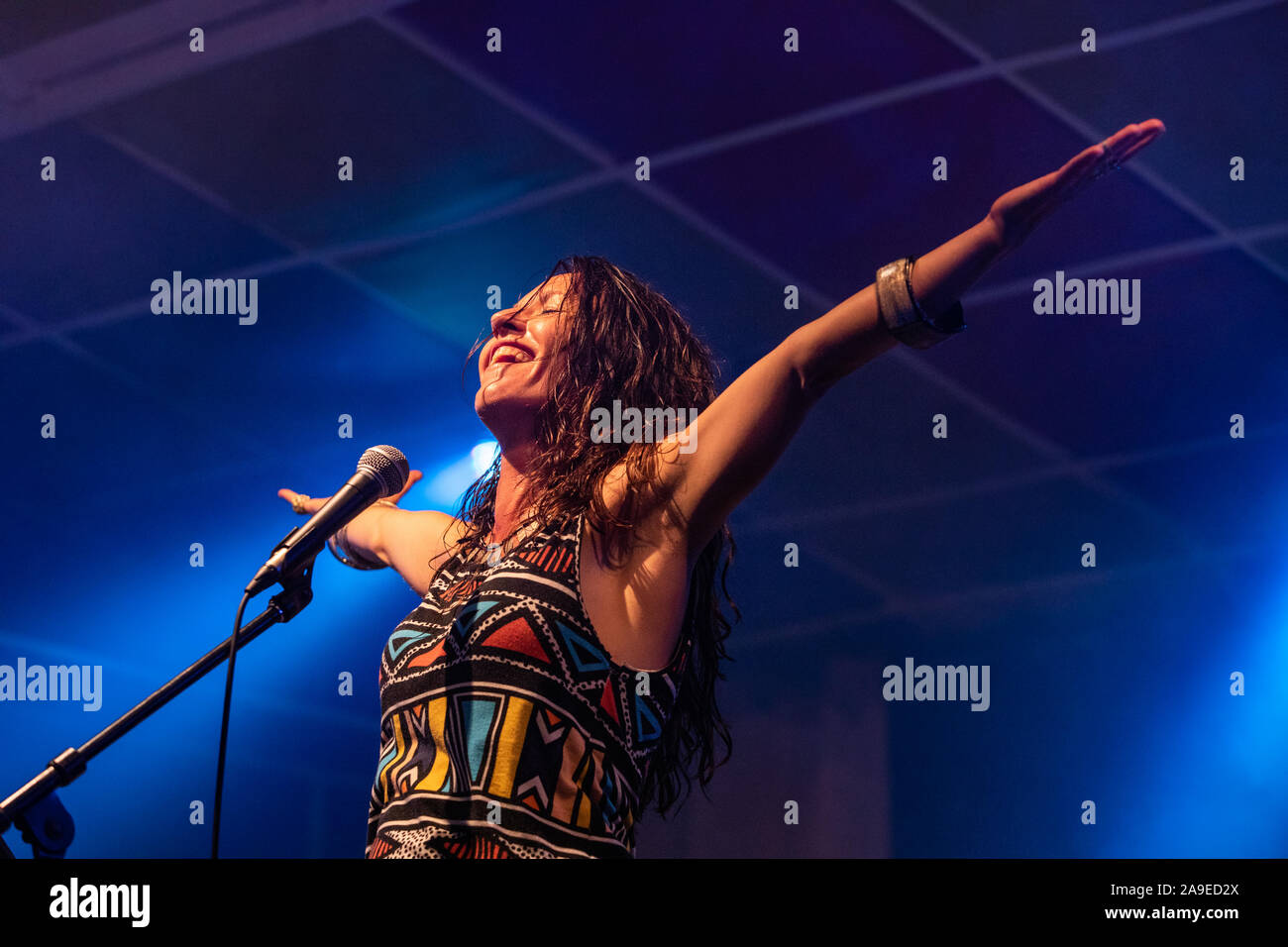 a female musician is viewed from a low angle as she sings and smiling ...