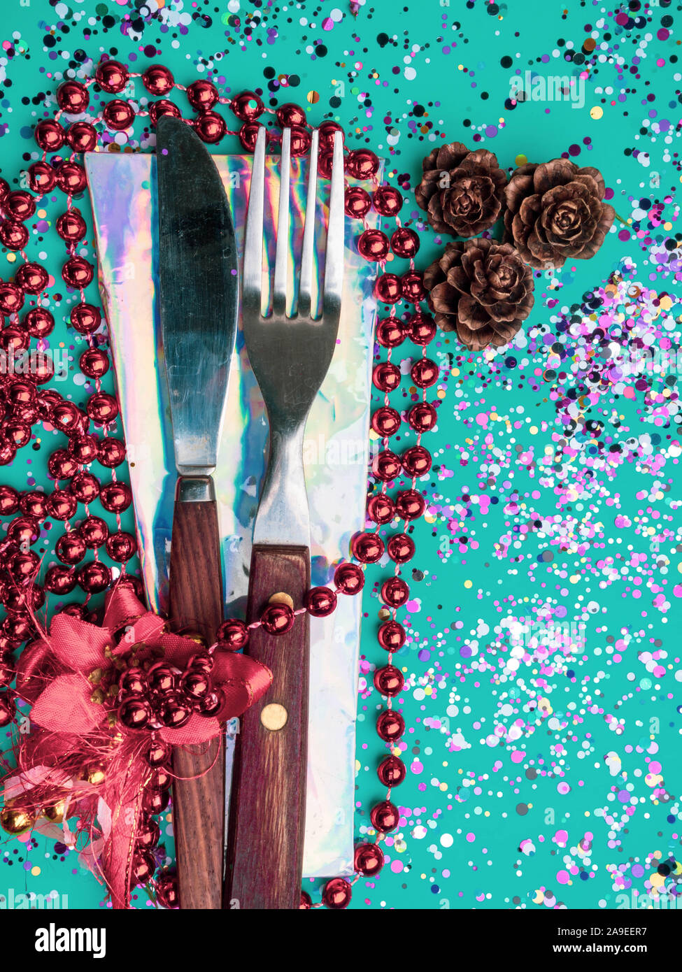 Christmas dinner table place setting on holographic paper with cutlery ...