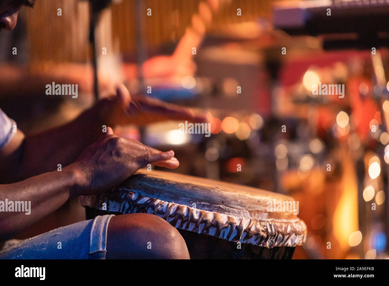 Close-up of man's hands playing on African djembe drum, selective focus ...