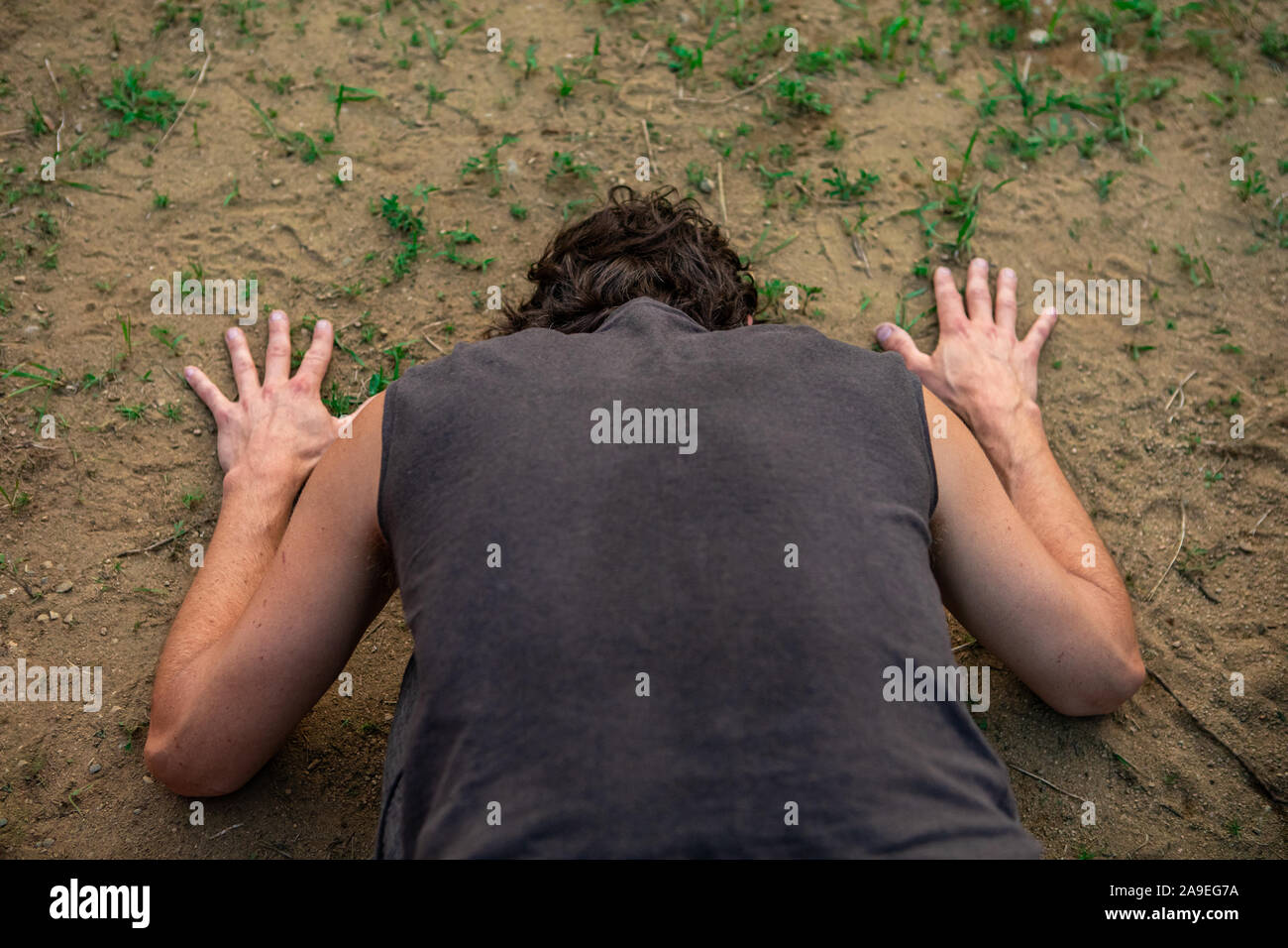 close up and high angle view of a man in a kneeling and bent forward ...