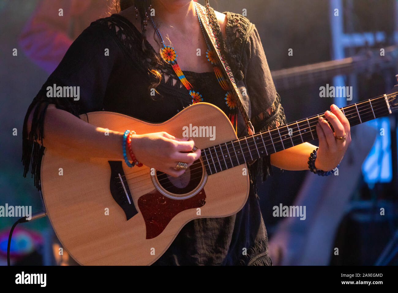 close-up view of musician woman playing guitar on the stage, female ...