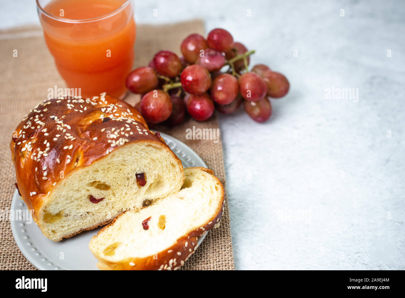 Breakfast brunch on table. Bread on plate, grapefruit juice and bunch ...