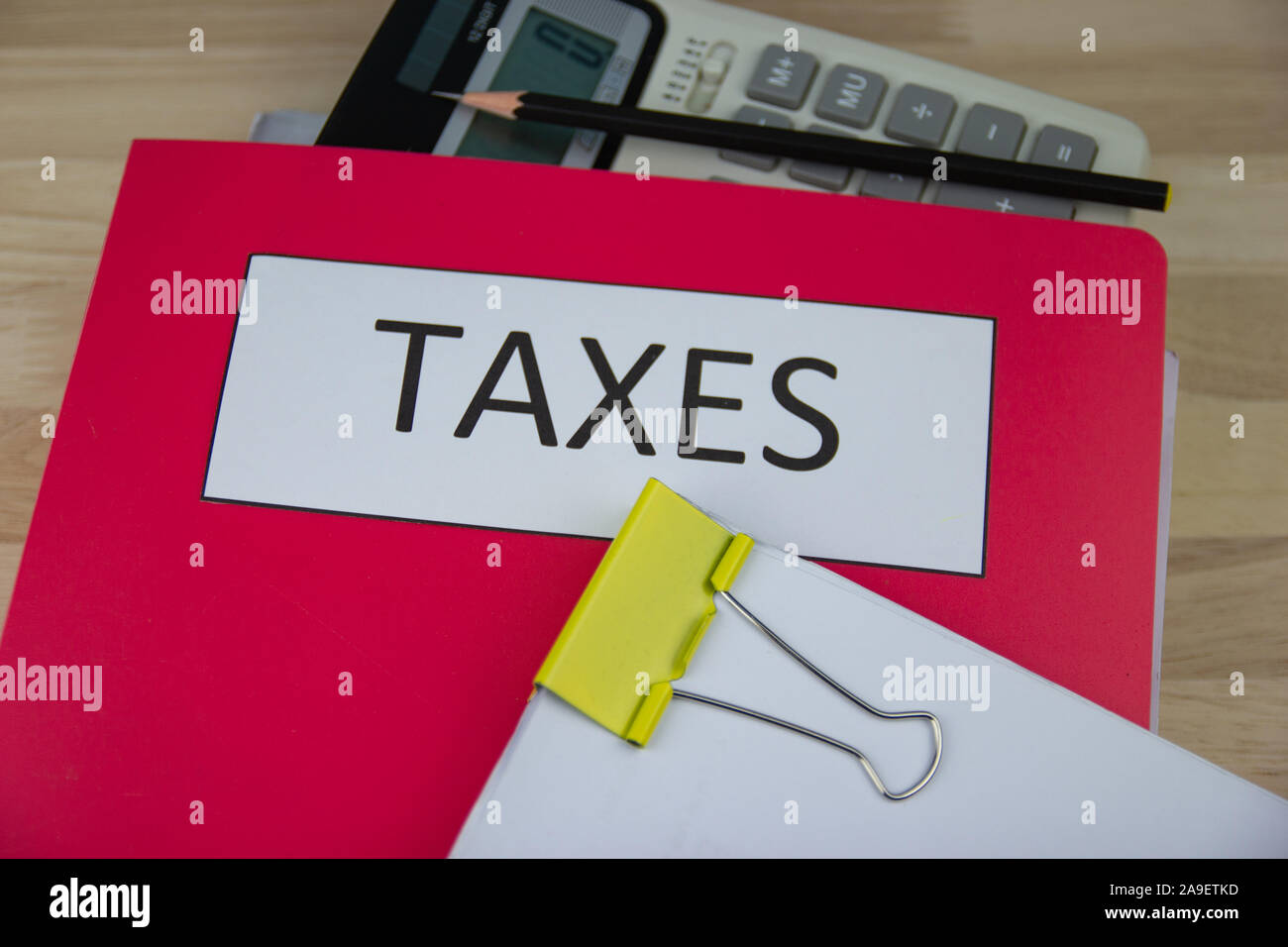 Tax documents and paper files, calculator on the wooden desk in the ...