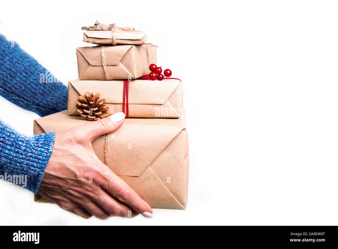 Female hands holding pile of gifts wrapped in craft paper with ribbons ...