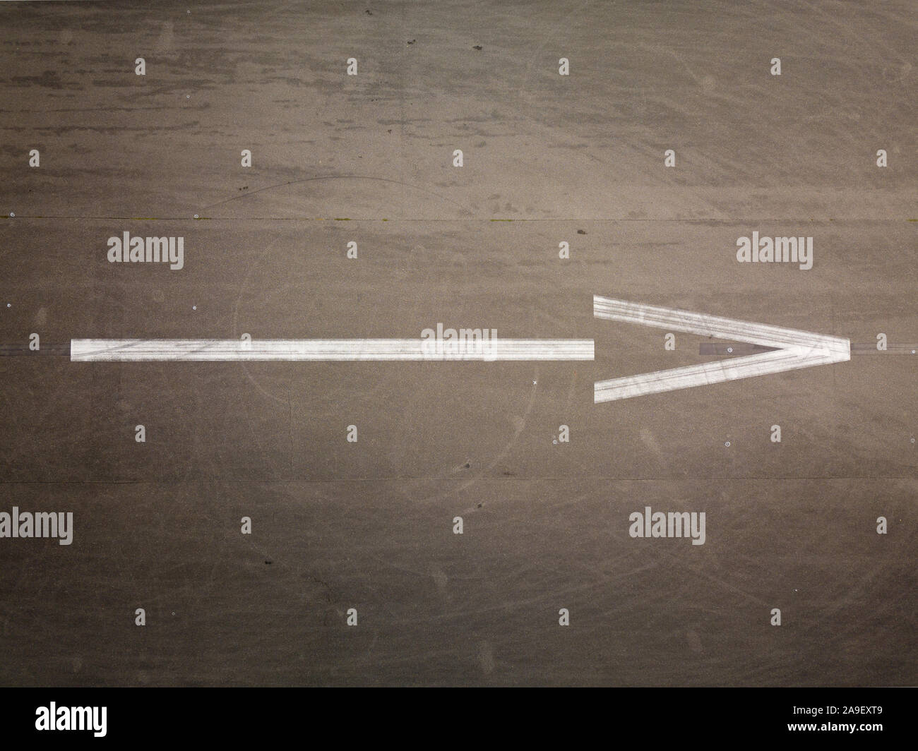 Flat lay picture of white arrow on a gray asphalt - Aerial drone top ...