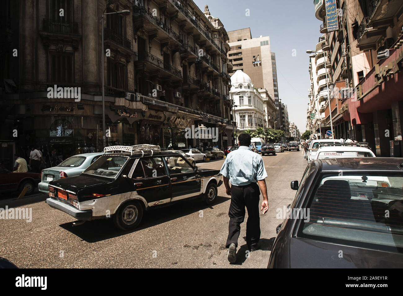 Cairo, Egypt, May 3, 2008: A man walks among cars down a busy road in ...