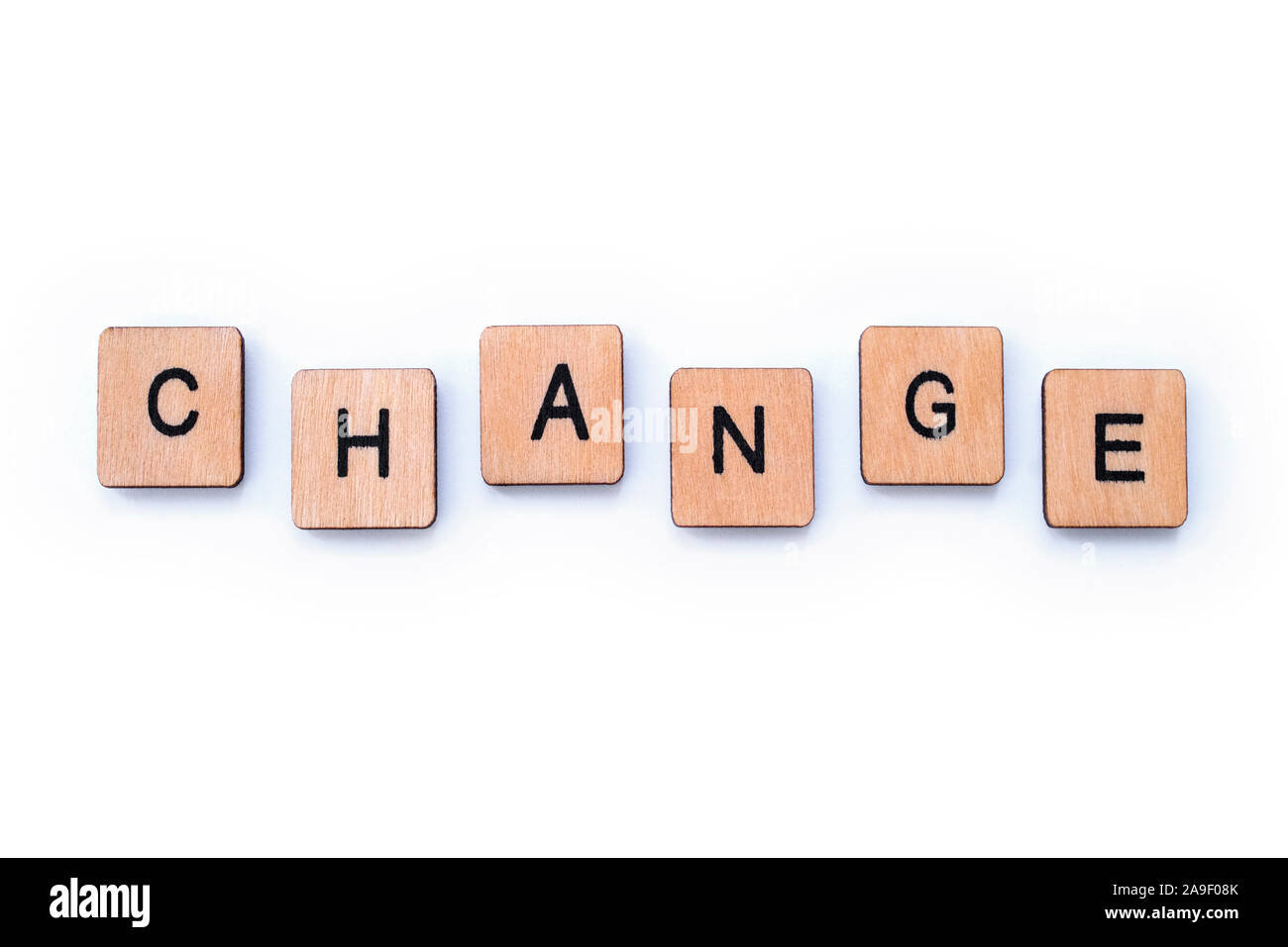 The word CHANGE, spelt with wooden letter tiles over a white background ...