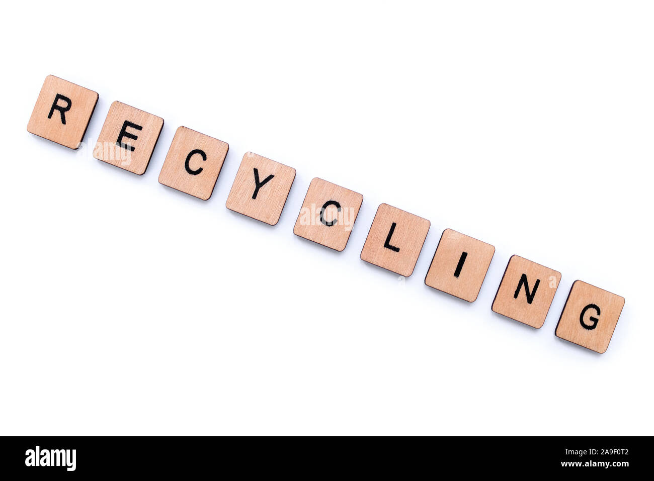 The word RECYCLING, spelt with wooden letter tiles over a white ...