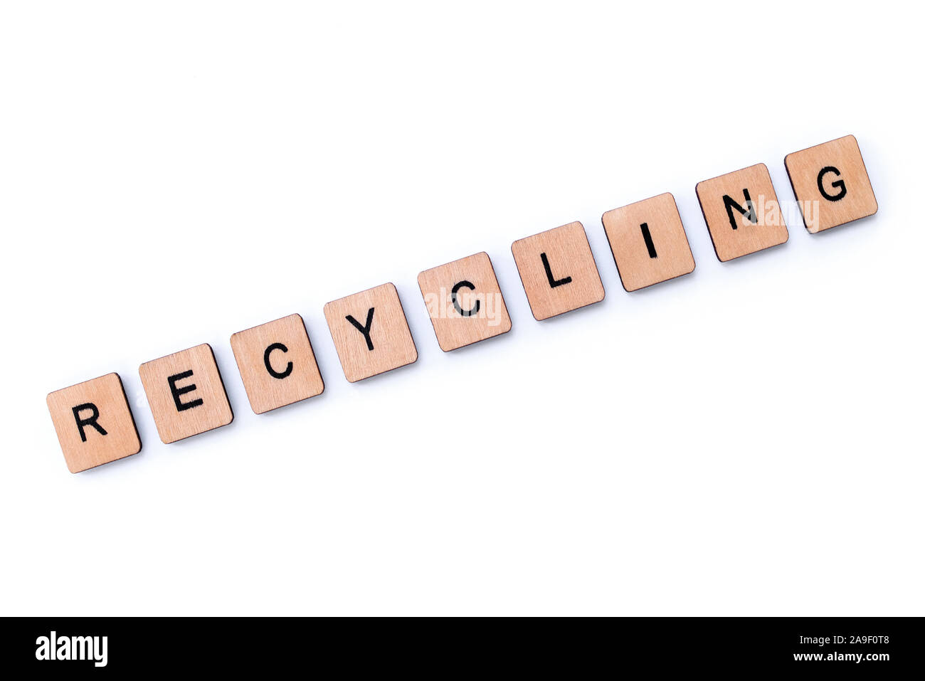 The word RECYCLING, spelt with wooden letter tiles over a white ...